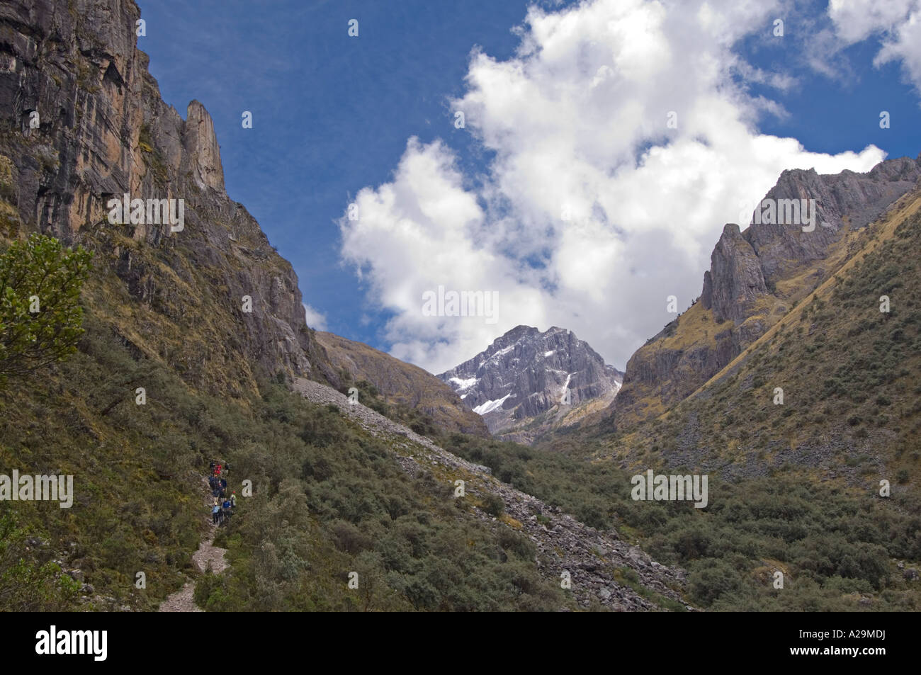 A group of tourists and guides trekking through the rugged scenery of ...