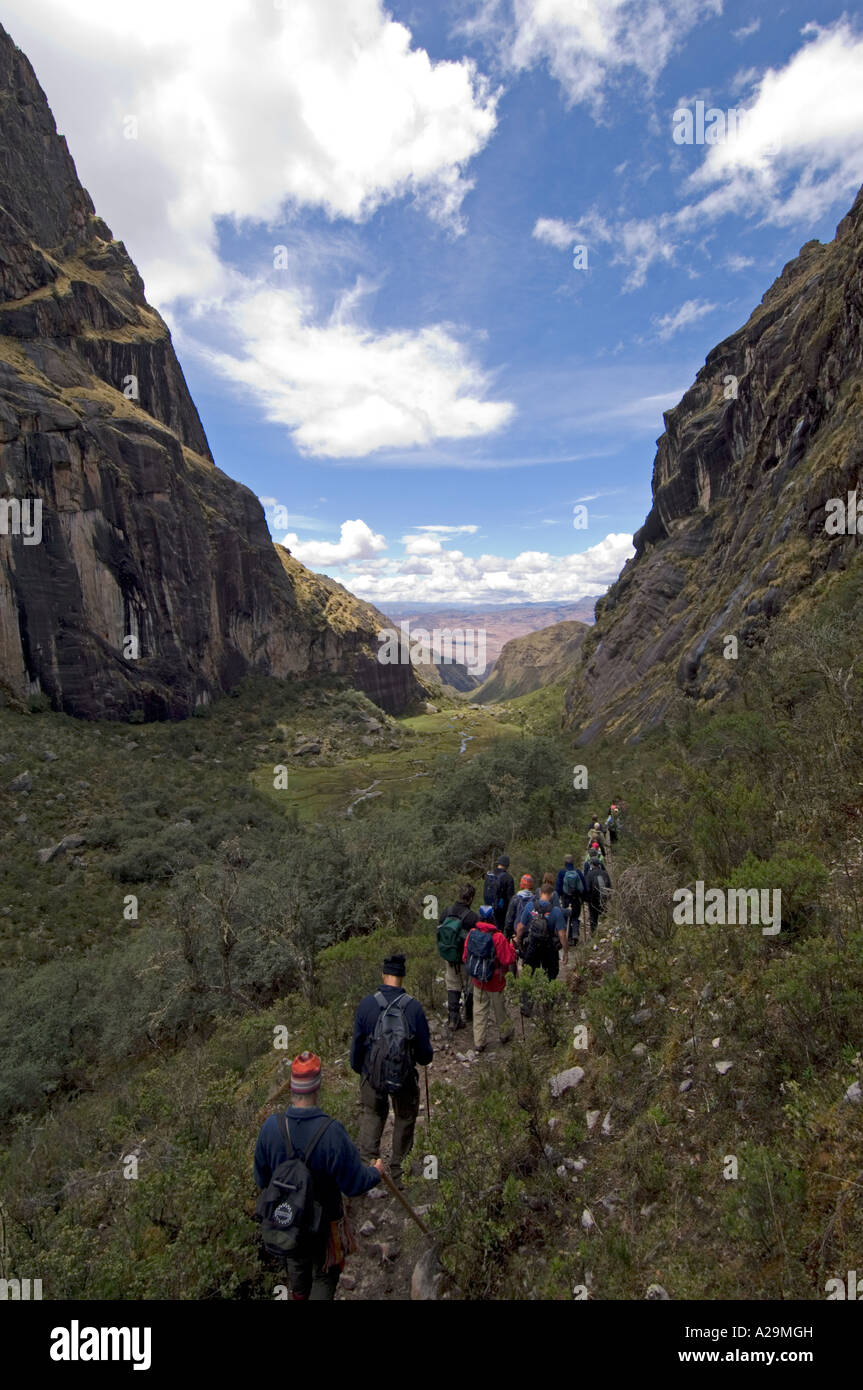 A group of tourists and guides trekking through the rugged scenery of ...