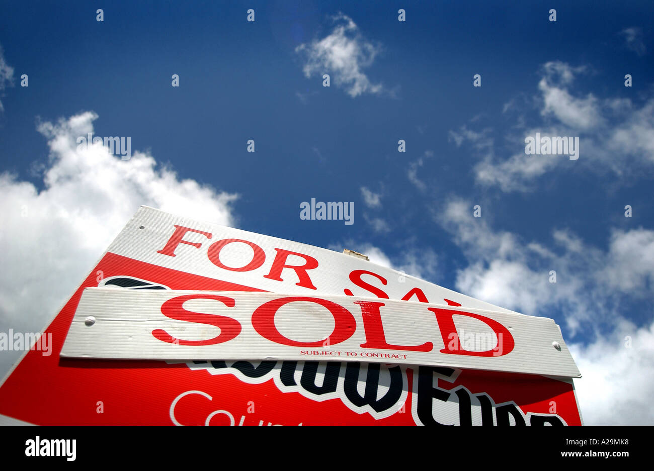 An estate agents for sale sold board sign against a blue sky Stock ...