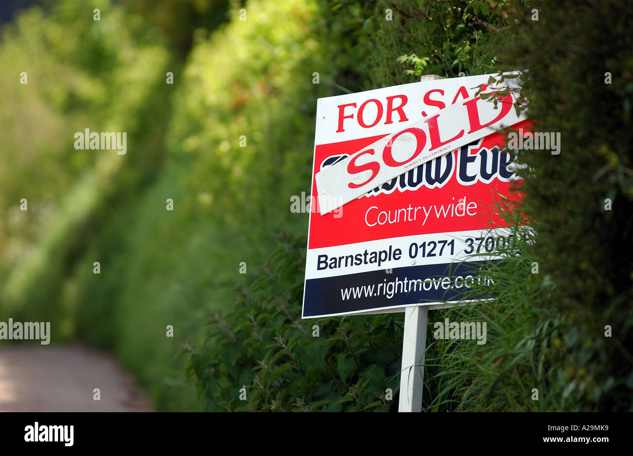 An estate agents board sign in a rural location showing sold and for ...
