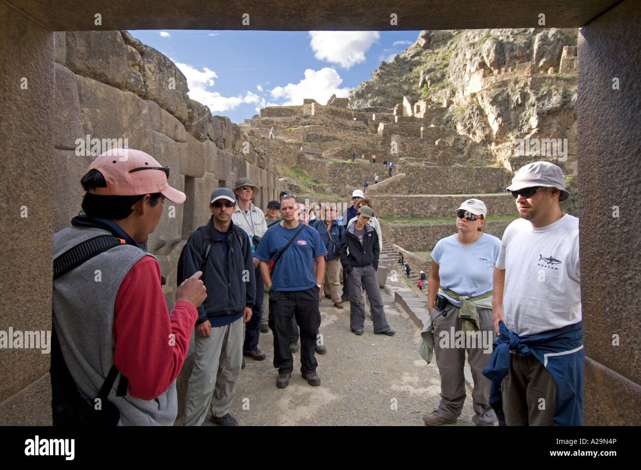 A guide explaining local history to a group of tourists at the Inca ...