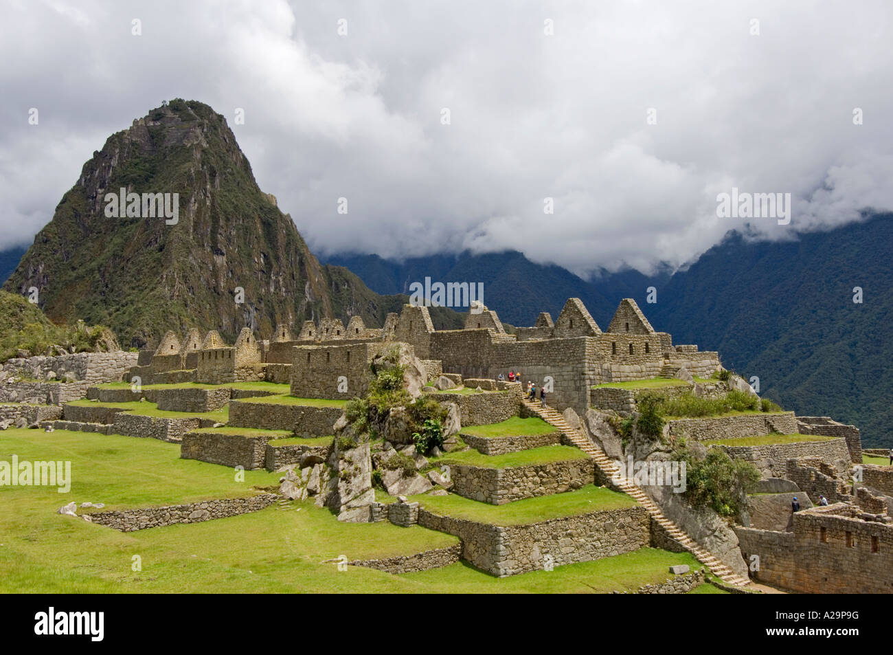 A group of tourists in the distance at the ancient Inca site of Machu ...