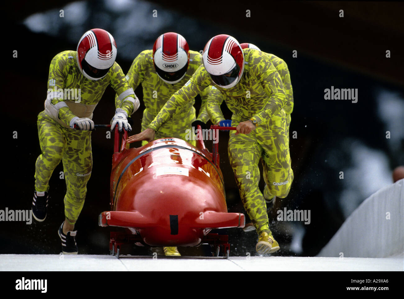 A 4 man Bobsleigh team pushing their bob at the start of a race Stock Photo - Alamy