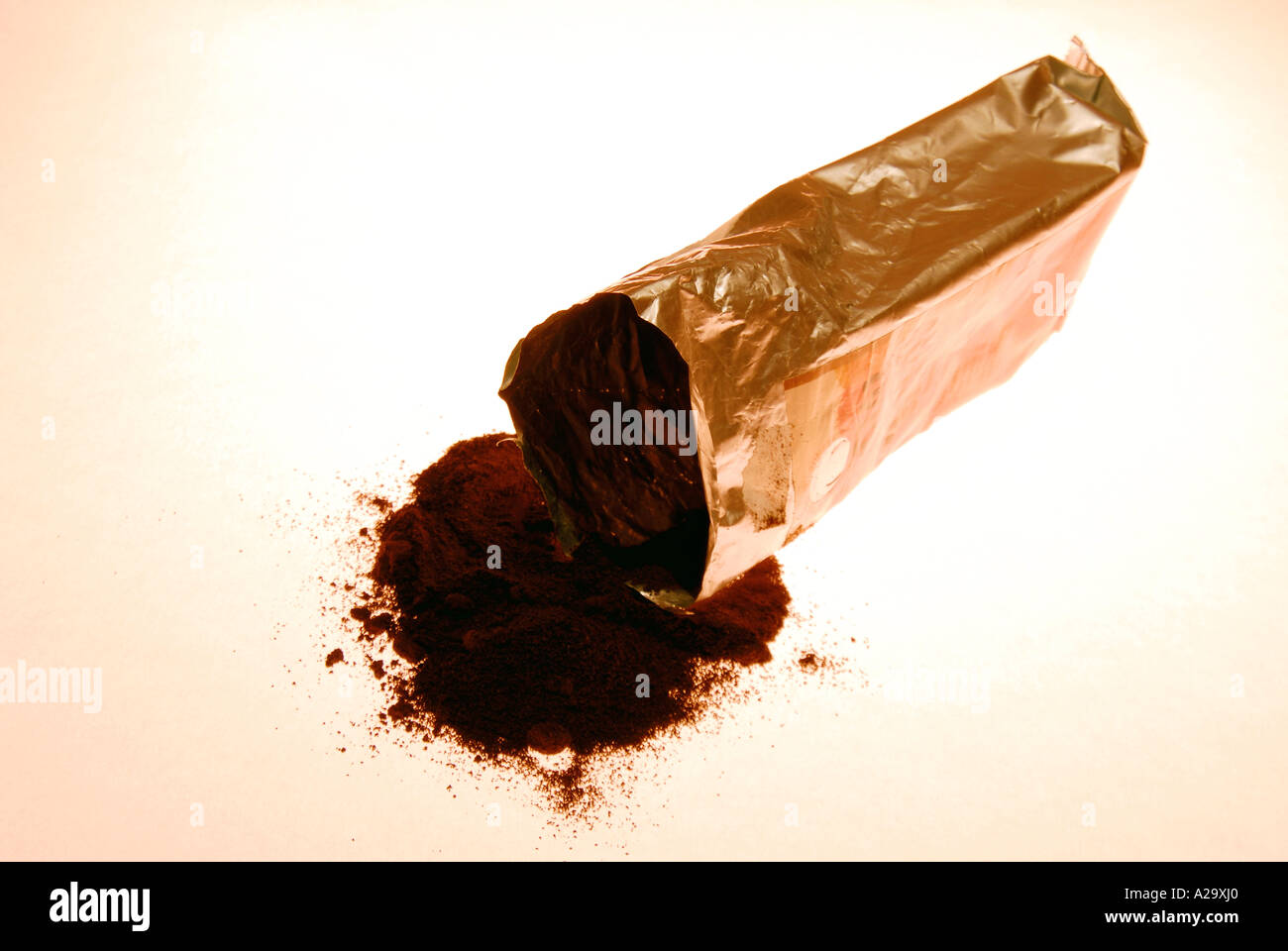 Ground coffee spilling from packet, elevated view Stock Photo - Alamy