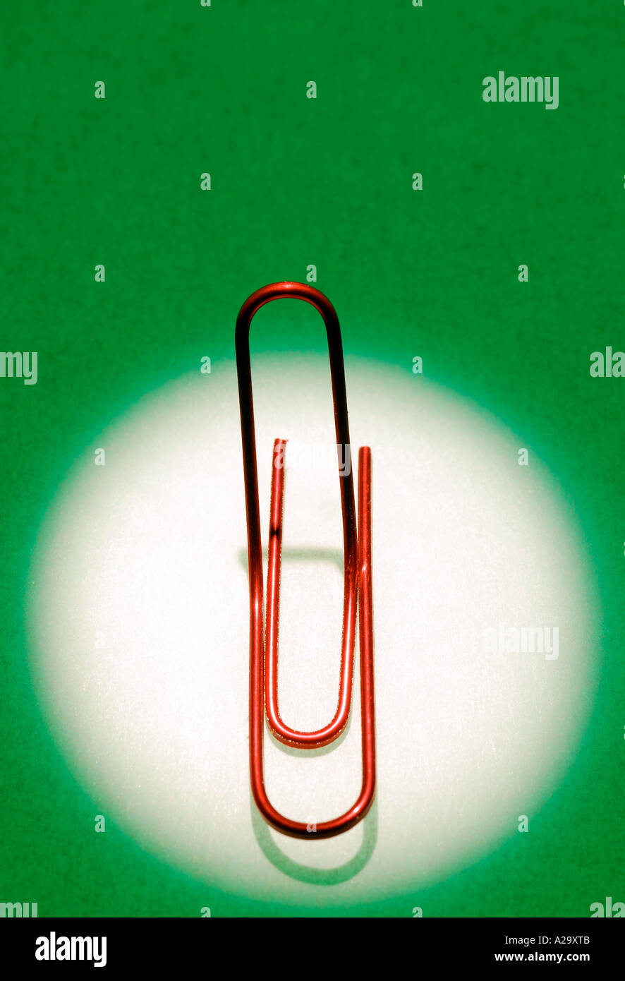 Paper clip against green background Stock Photo - Alamy