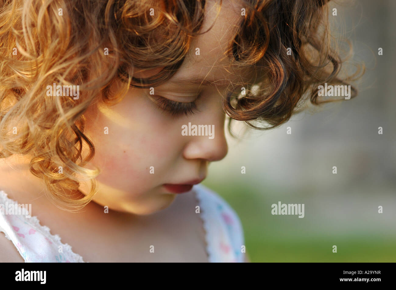 Closeup of a cute girls face - looking down as if she'd be sad Stock ...