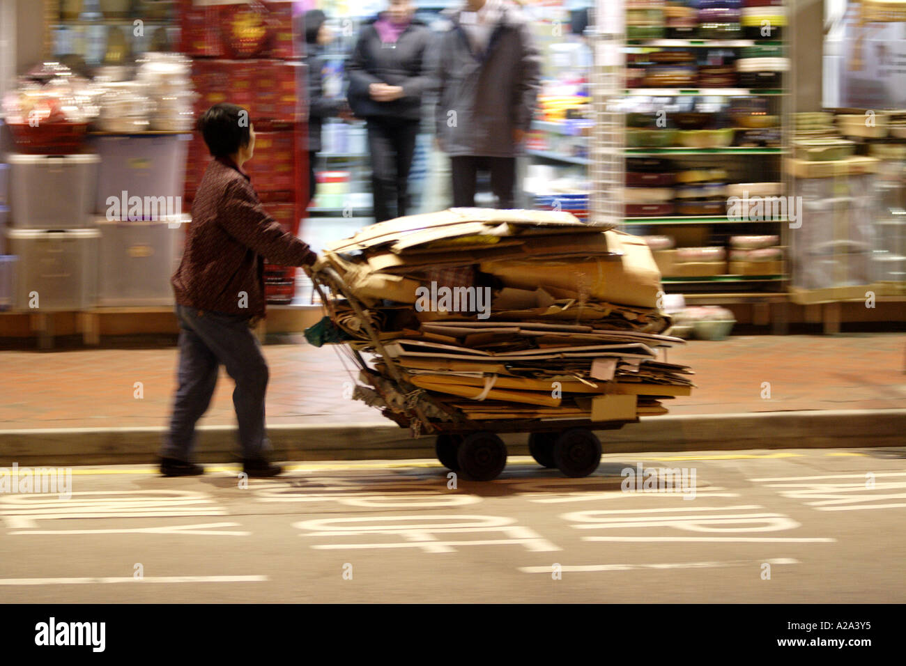 Woman pushes a cart stacked with recycled cardboard, Hong Kong, China ...