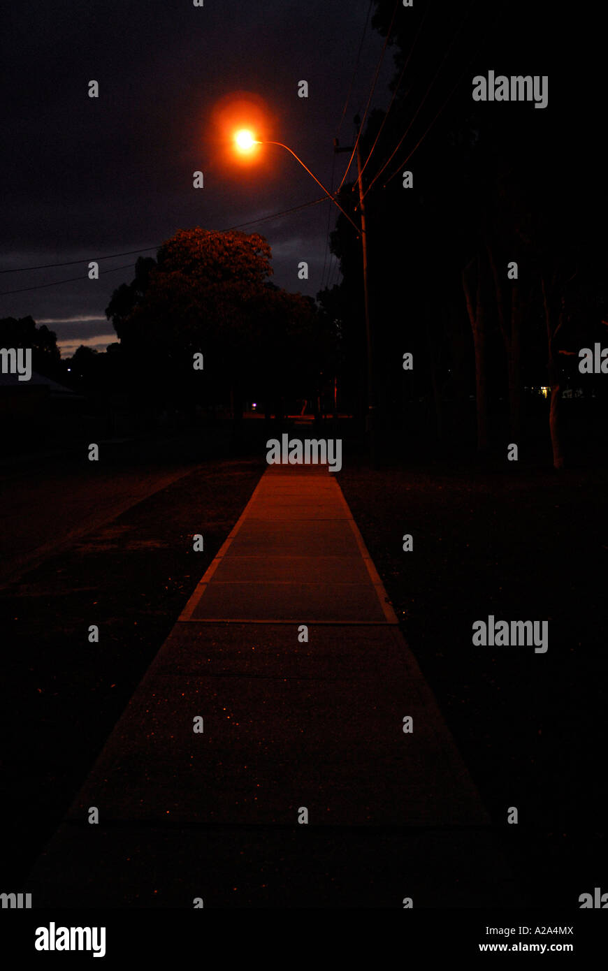 solitary street light over dimly lit footpath at night Stock Photo - Alamy