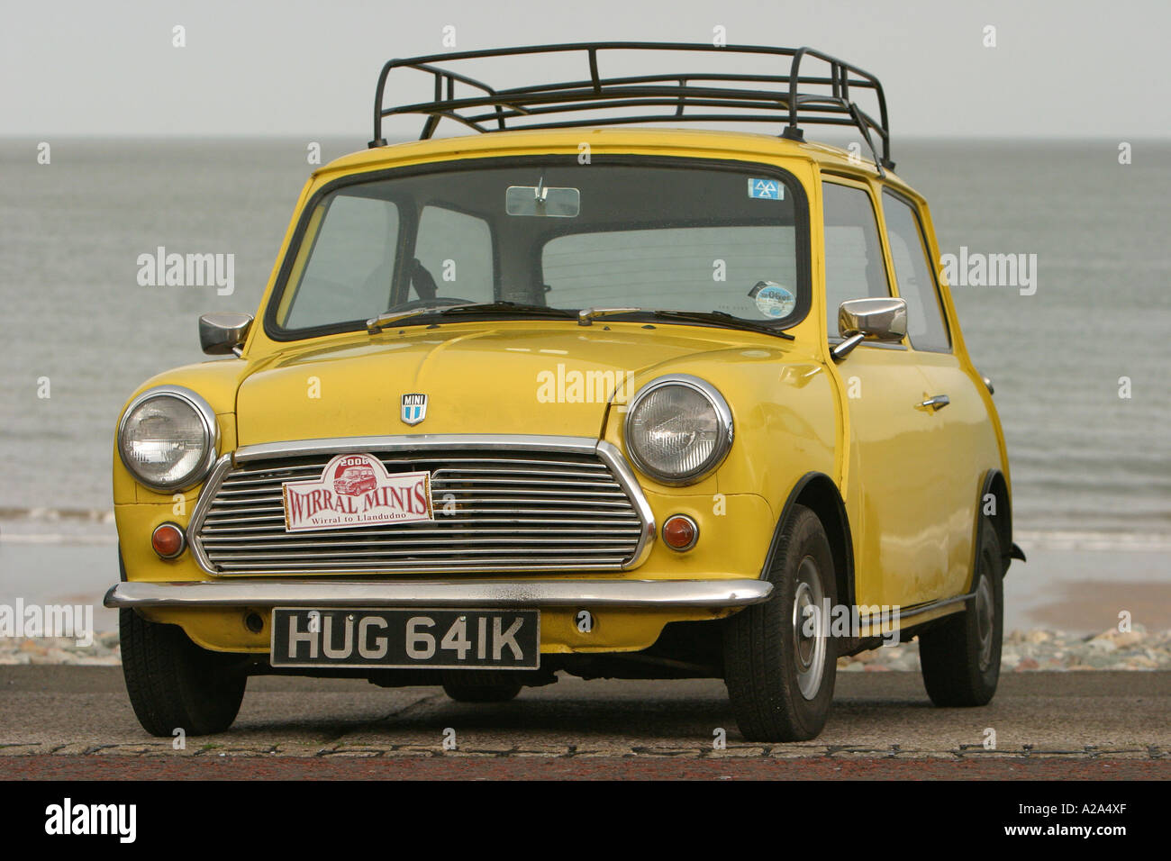 yellow mini with a roofrack on parked up at the seaside sea side beach ...