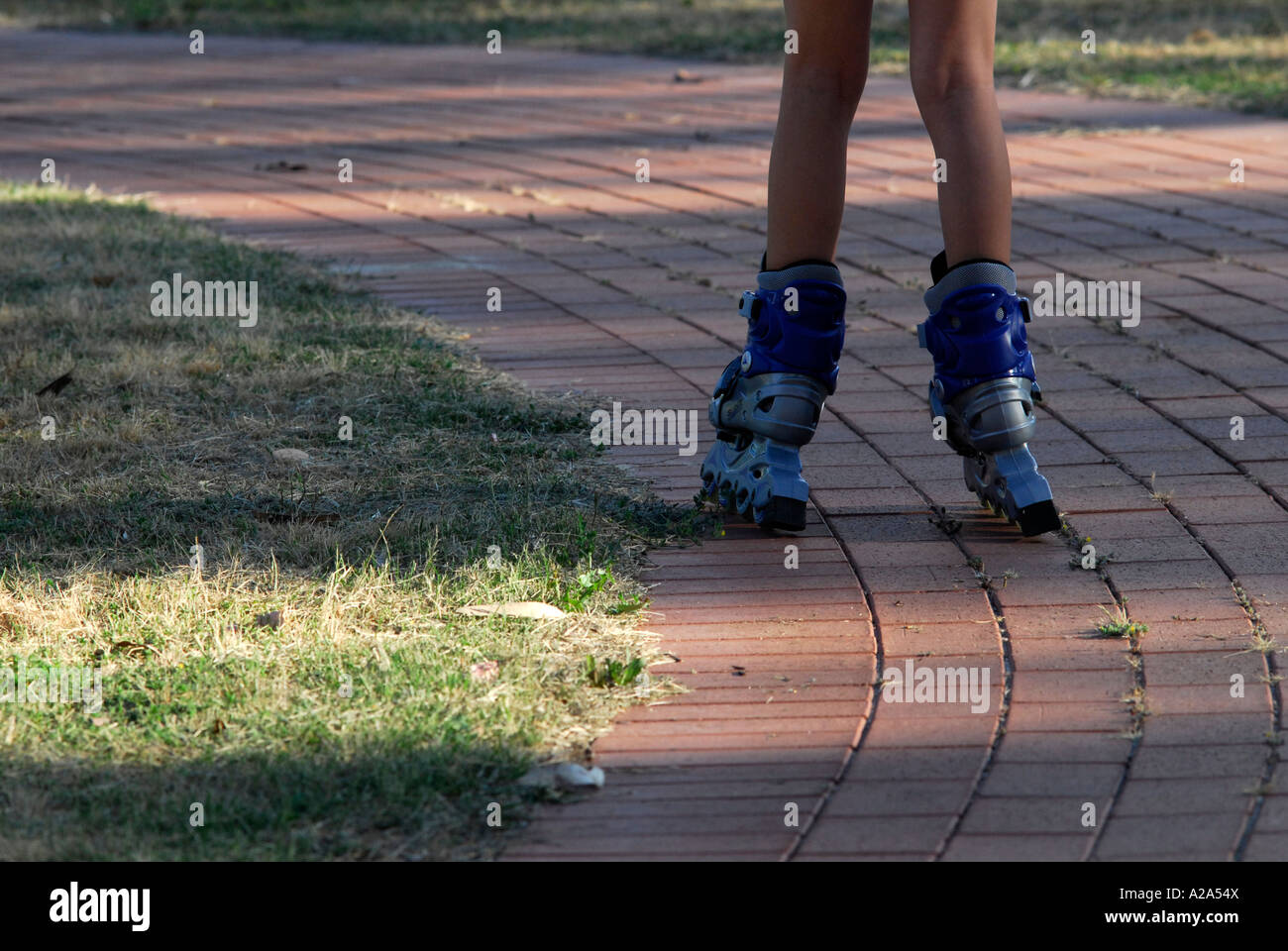 young girl skating on inline skates on brick path Stock Photo - Alamy