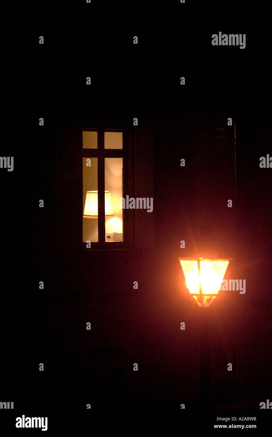 Streetlight in front of a lit window illuminated at night Stock Photo ...