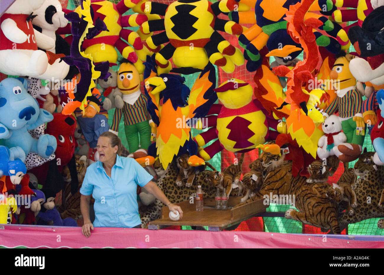 Carney worker promoting game from booth Stock Photo - Alamy