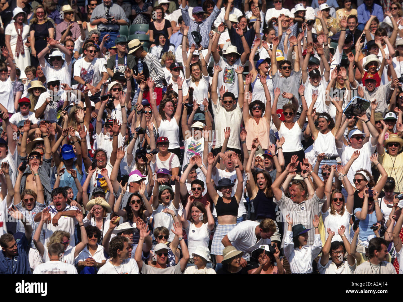 People in the crowd raise their arms in the air performing a Mexican ...