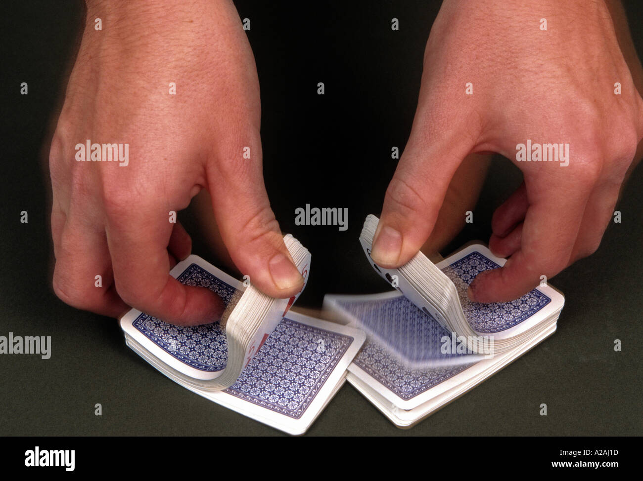 Close up of two hands shuffling a pack of playing cards Stock Photo - Alamy