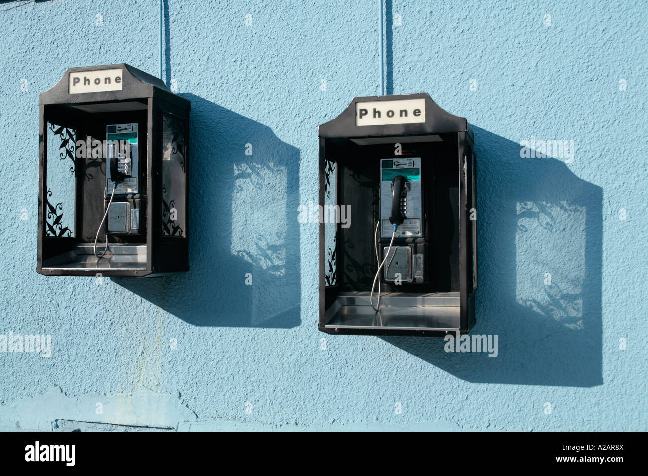 two public telephone boxes on blue rendered wall Stock Photo - Alamy