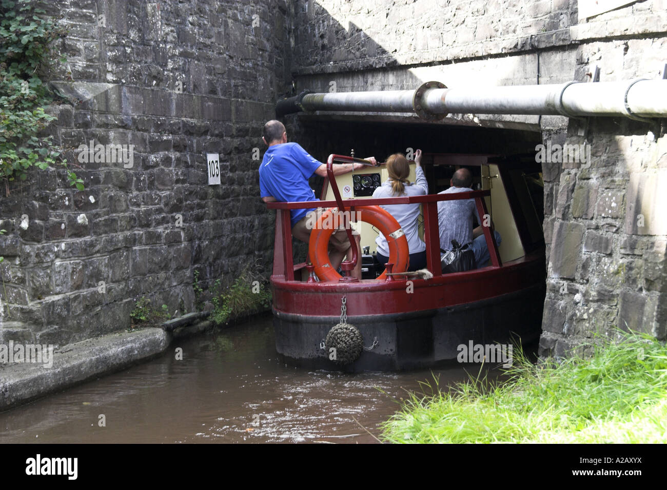Canal boat passing under very low bridge on brecon canal Stock Photo ...