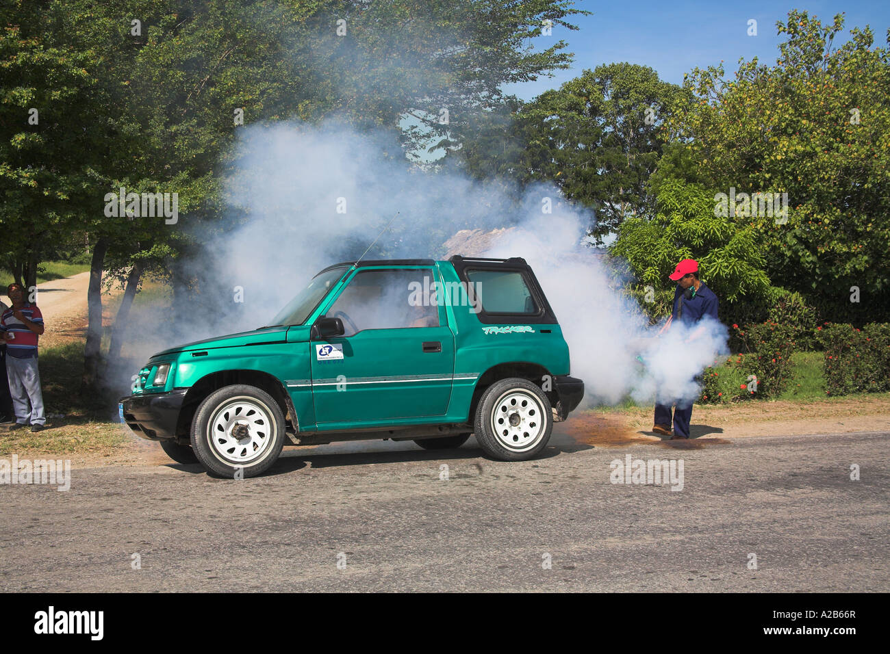 Car being fumigated with insecticide to kill mosquito larvae, near ...