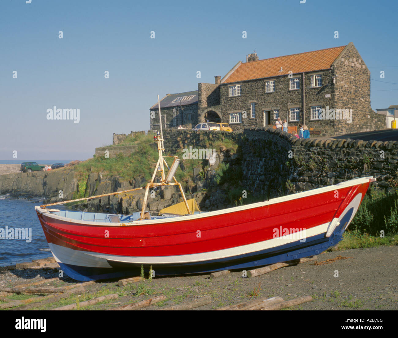 A traditional wooden coble fishing boat and the harbour, Craster ...