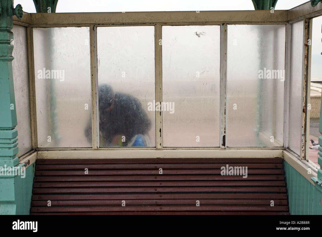 Tramp in a shelter on Brighton Promenade Brighton UK Stock Photo - Alamy