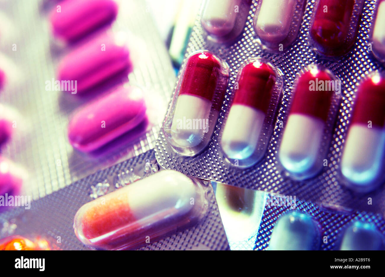 Various capsules and tablets in bright colors are organized in blisters ...