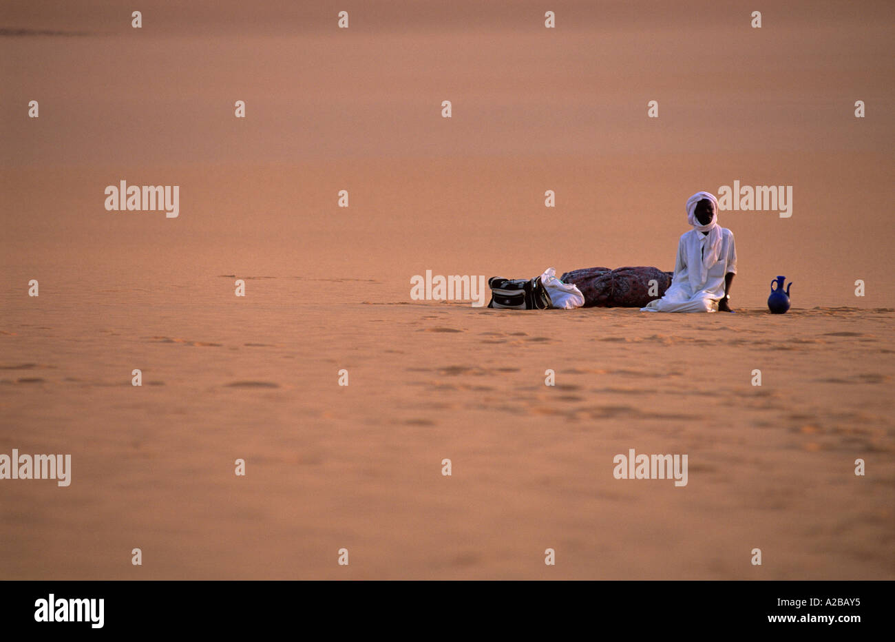 Praying muslim sitting in the sand Stock Photo - Alamy