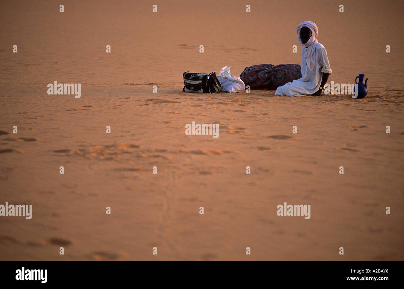 Praying muslim sitting in the sand Stock Photo - Alamy