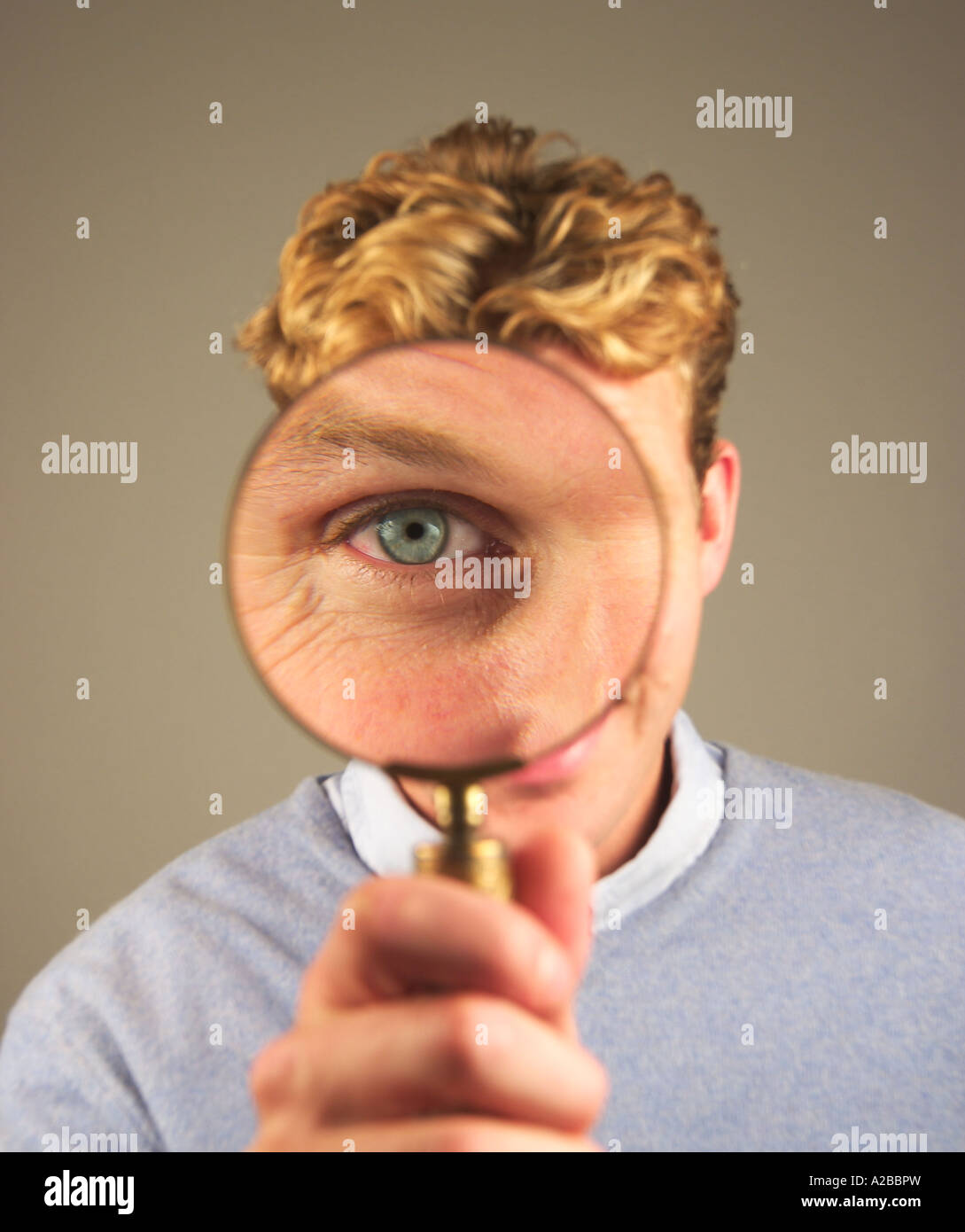 man looking through a magnifying glass Stock Photo - Alamy