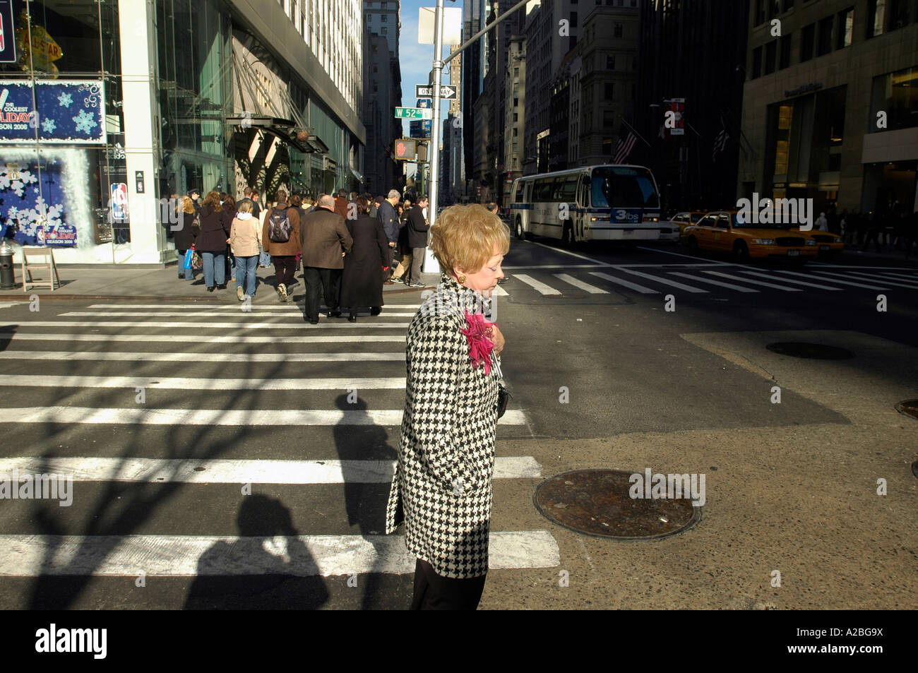 A woman waits to cross Fifth Avenue in Midtown Manhattan Stock Photo ...