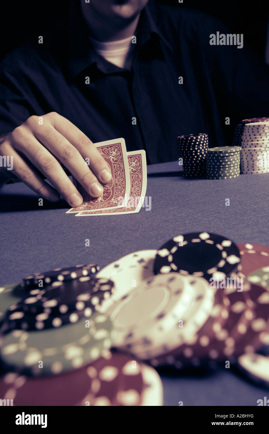 Young man looking at cards in poker game Stock Photo - Alamy