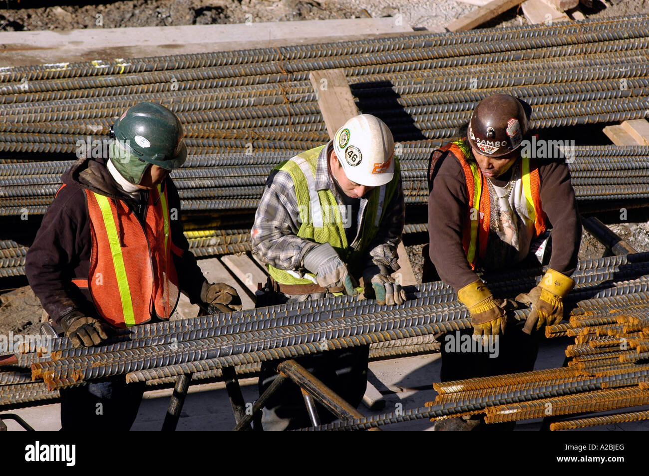 A project manager shows ironworkers where to cut some rebar at a ...