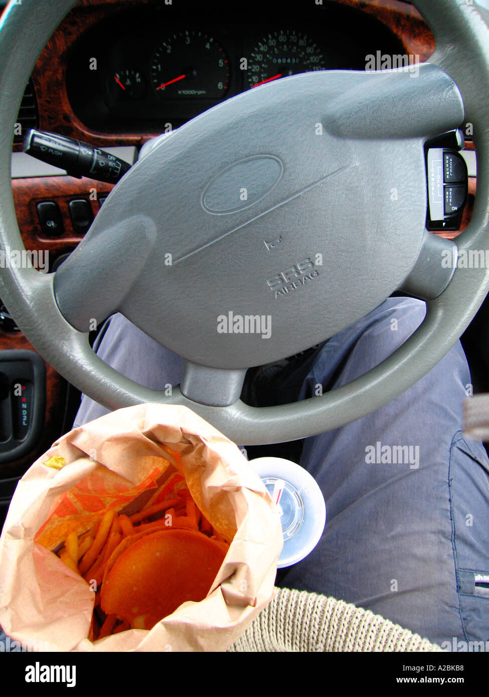 Eating fast food on the move driving car Stock Photo - Alamy