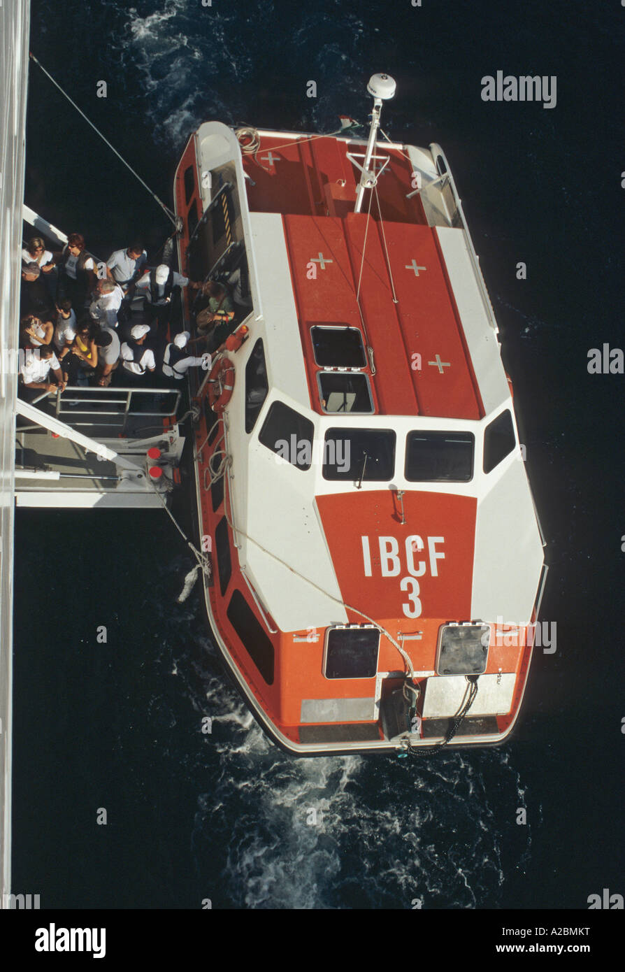 passengers desembarking from a tender boat to get onboard a cruise ship ...