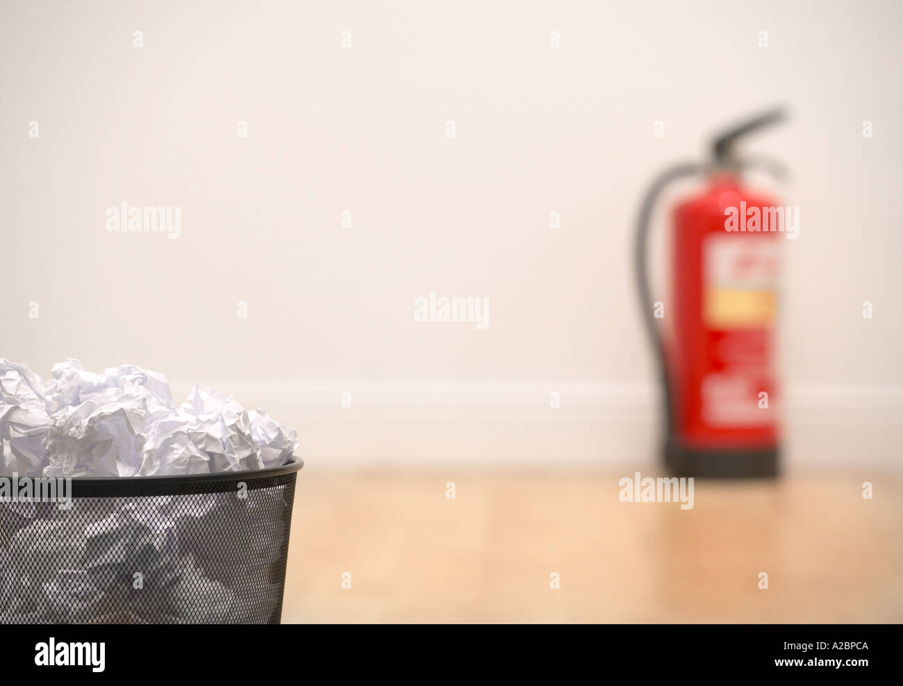 LITTER BIN FULL OF CRUMPLED WASTE PAPER ON WOOD OFFICE FLOOR WITH FIRE ...