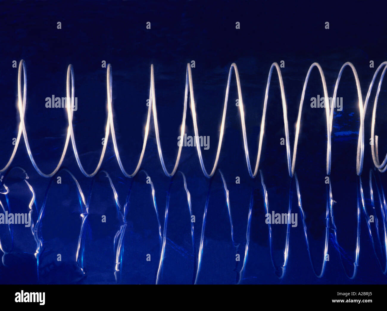 Isolated coiled metal spring. Industrial design. Shiny single metallic ...