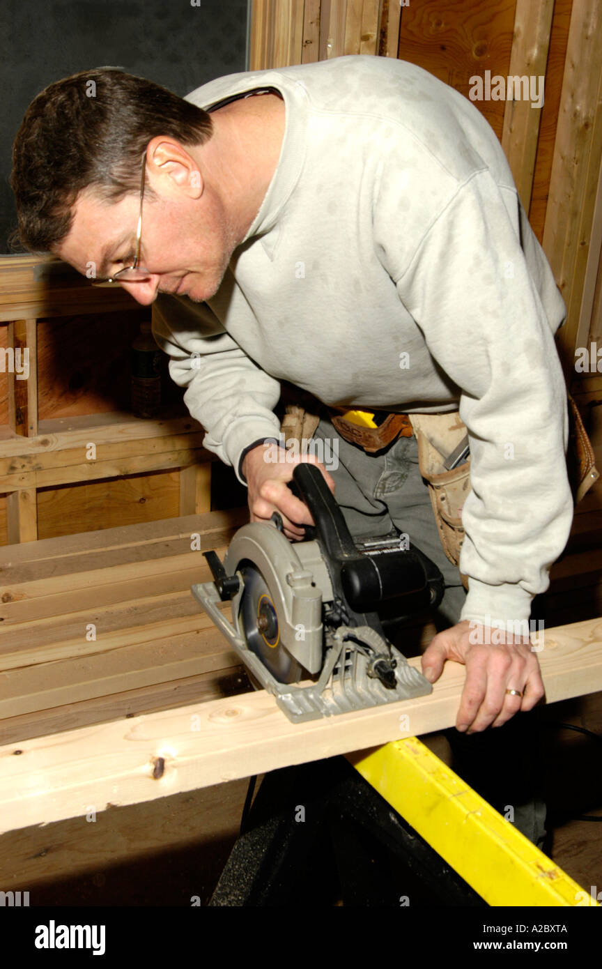 Carpenter using skill saw to cut board Stock Photo - Alamy