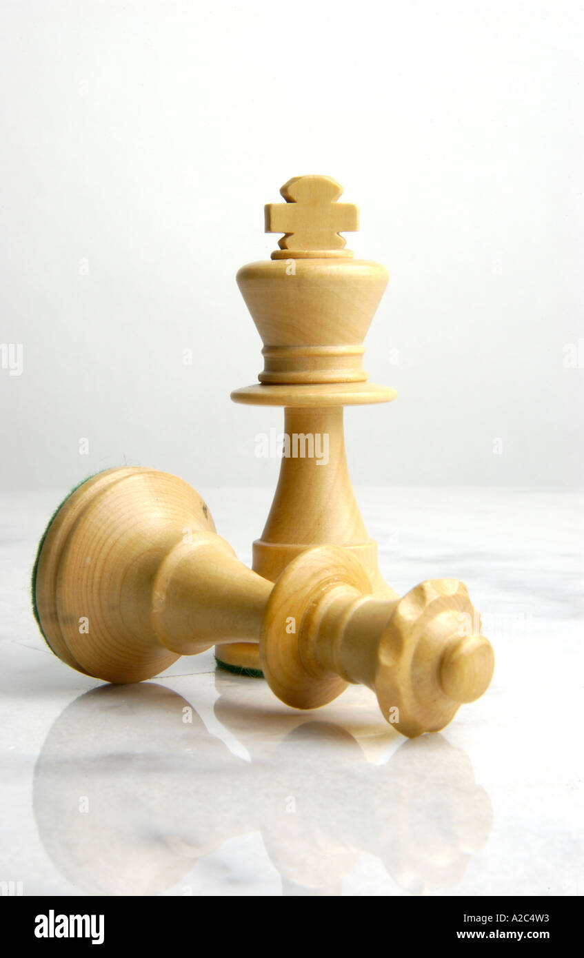 Two wooden chess pieces are artistically positioned on a smooth marble ...