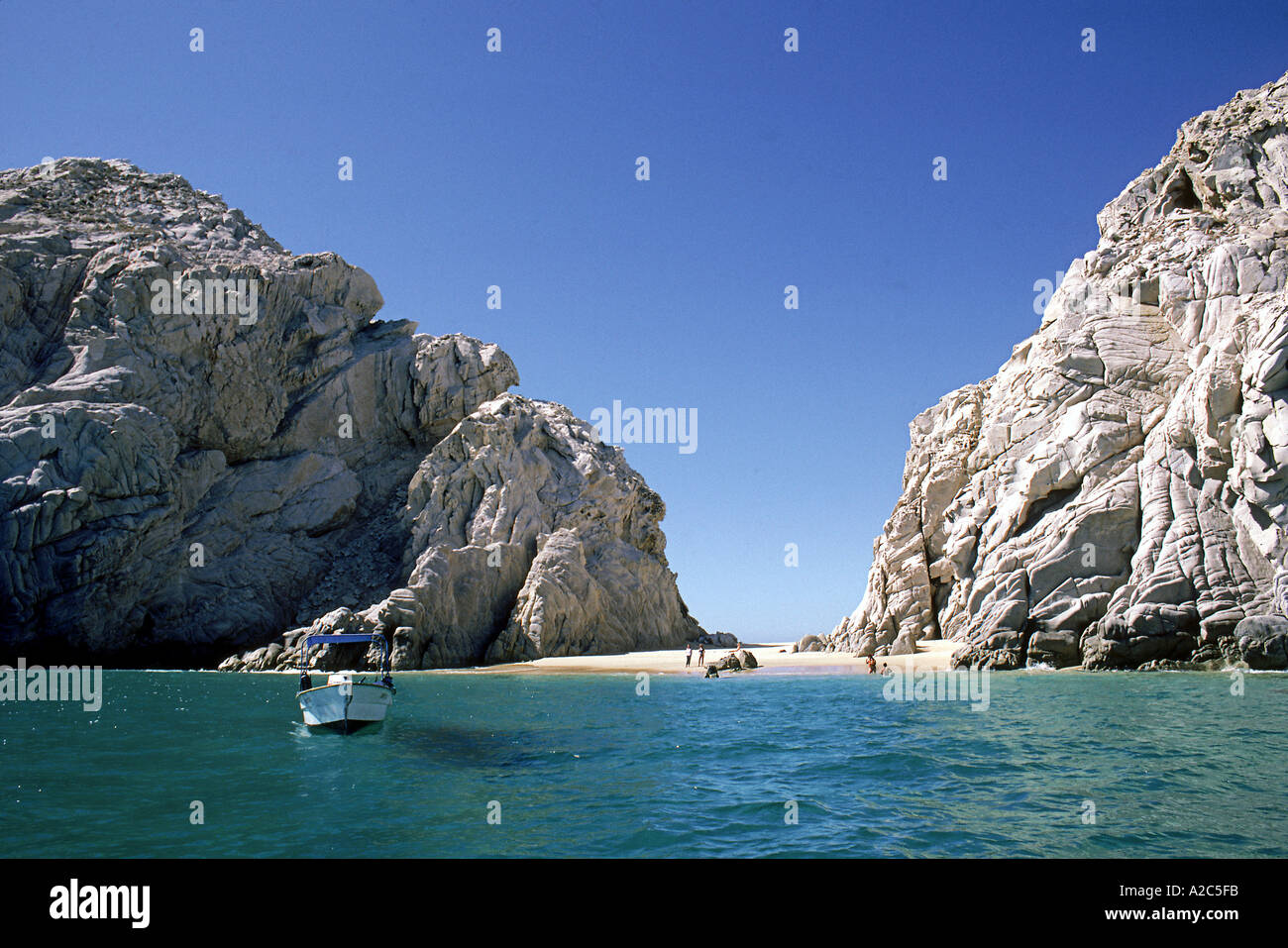 Horizontal shot of small boat in water near beach in Cabo San Lucas ...