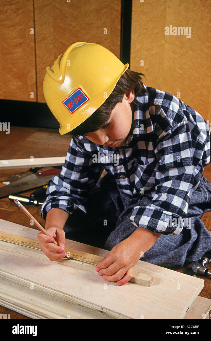 Vertical shot of young boy playing grown up carpenter worker Stock ...