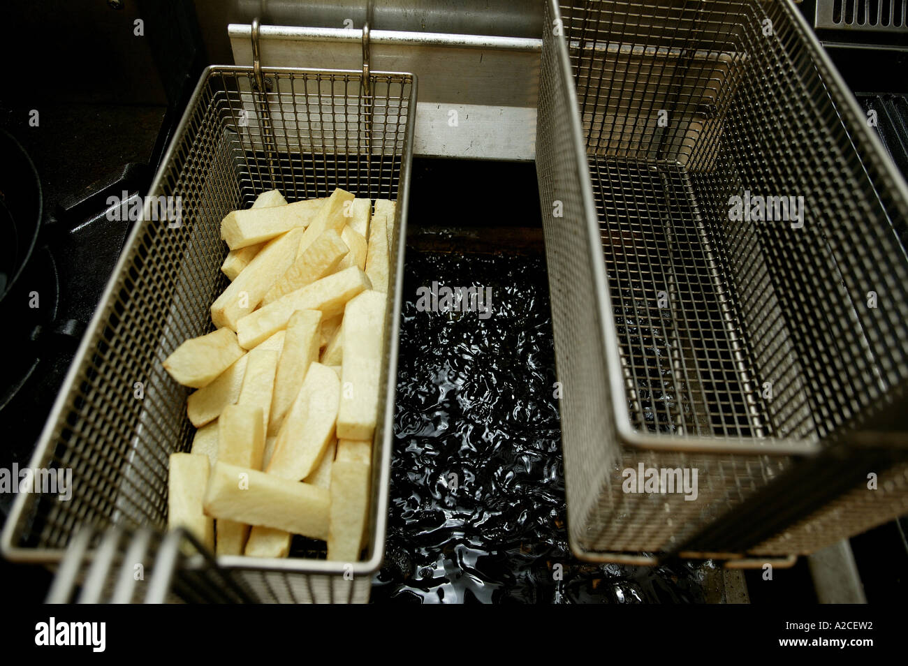 Chips being lowered into oil Stock Photo - Alamy