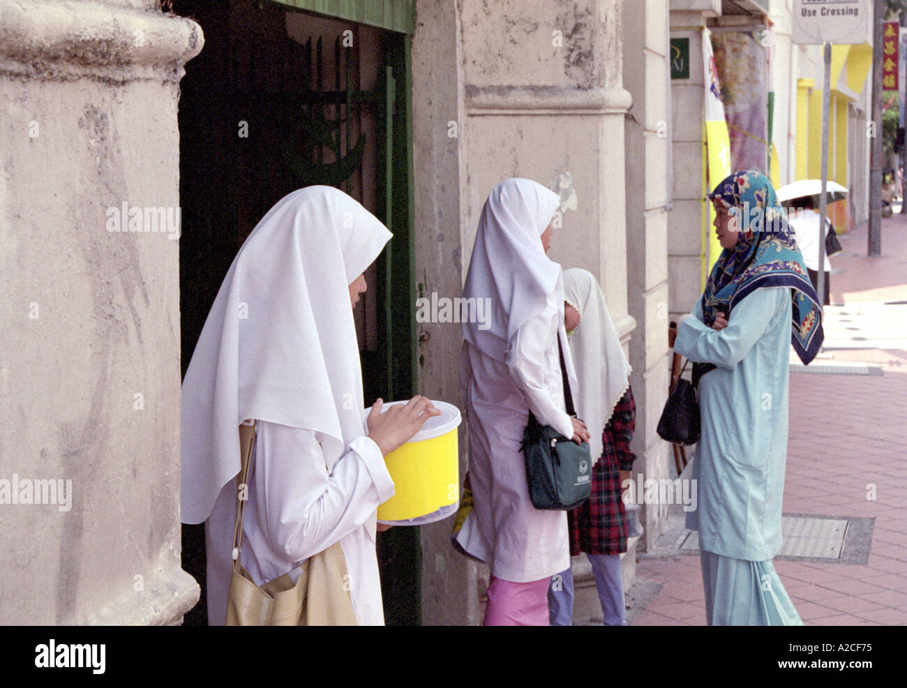 Singaporean muslim women standing by the mosque entrance Jamae Mosque ...