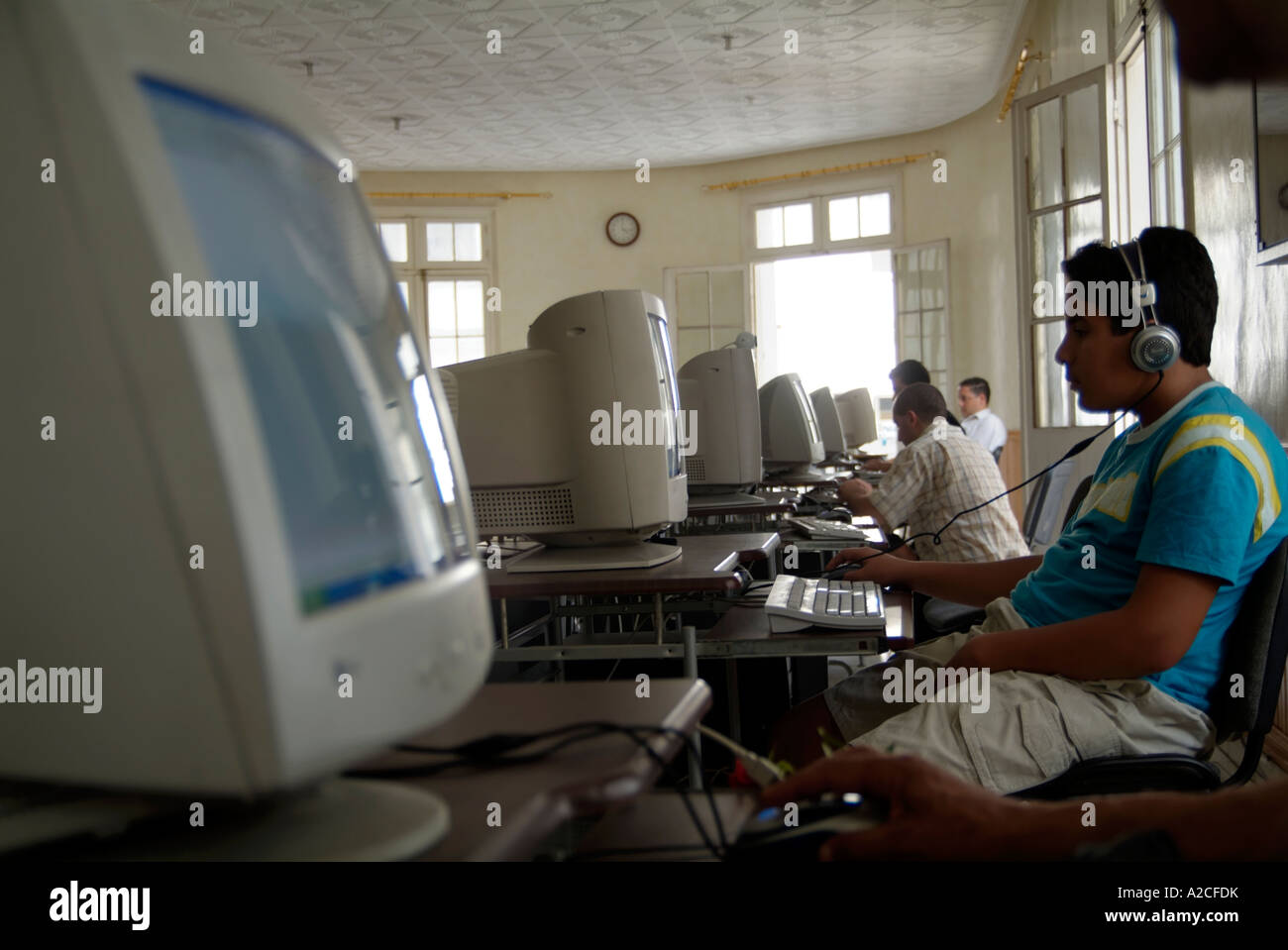 People working at a line of computers in an internet cafe in Tangiers ...