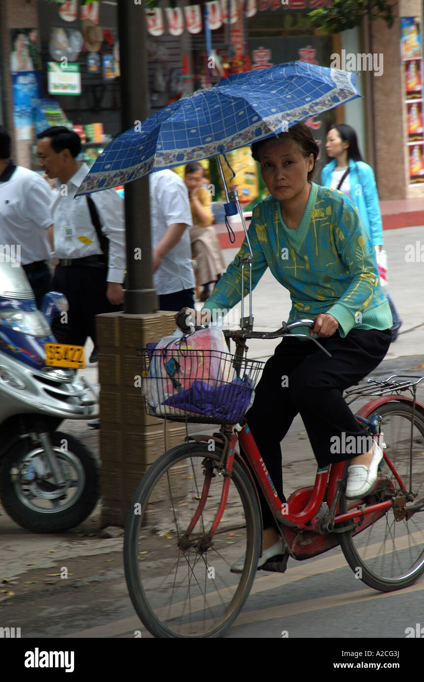 Woman riding bike, Leshan China Stock Photo - Alamy