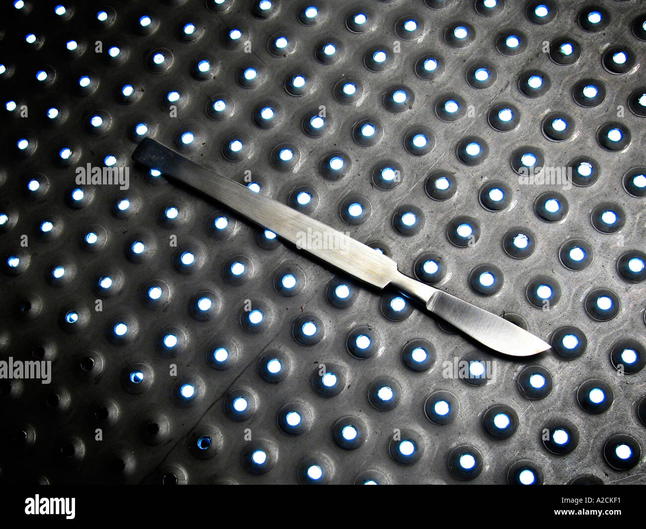Surgical knife on metal grid Stock Photo - Alamy