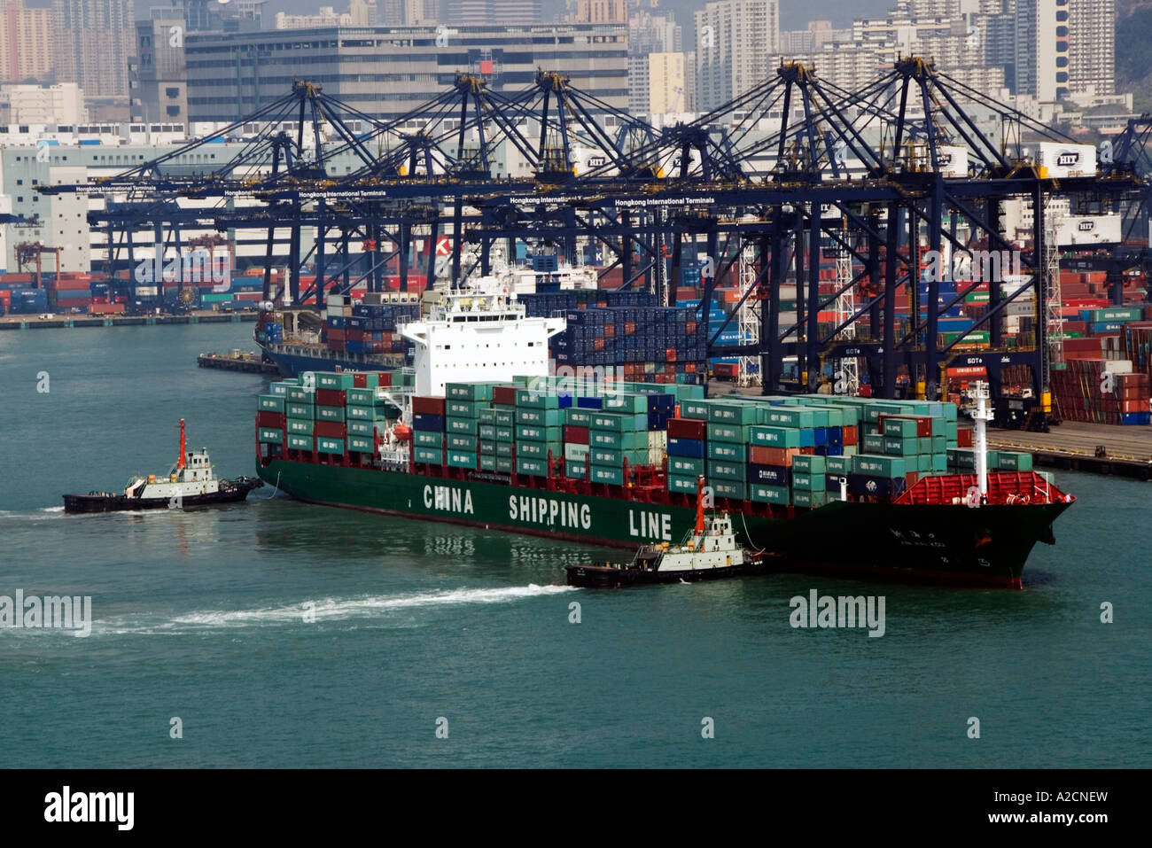 Large container ship being pushed into quay by tugs at Kwai Chung port ...
