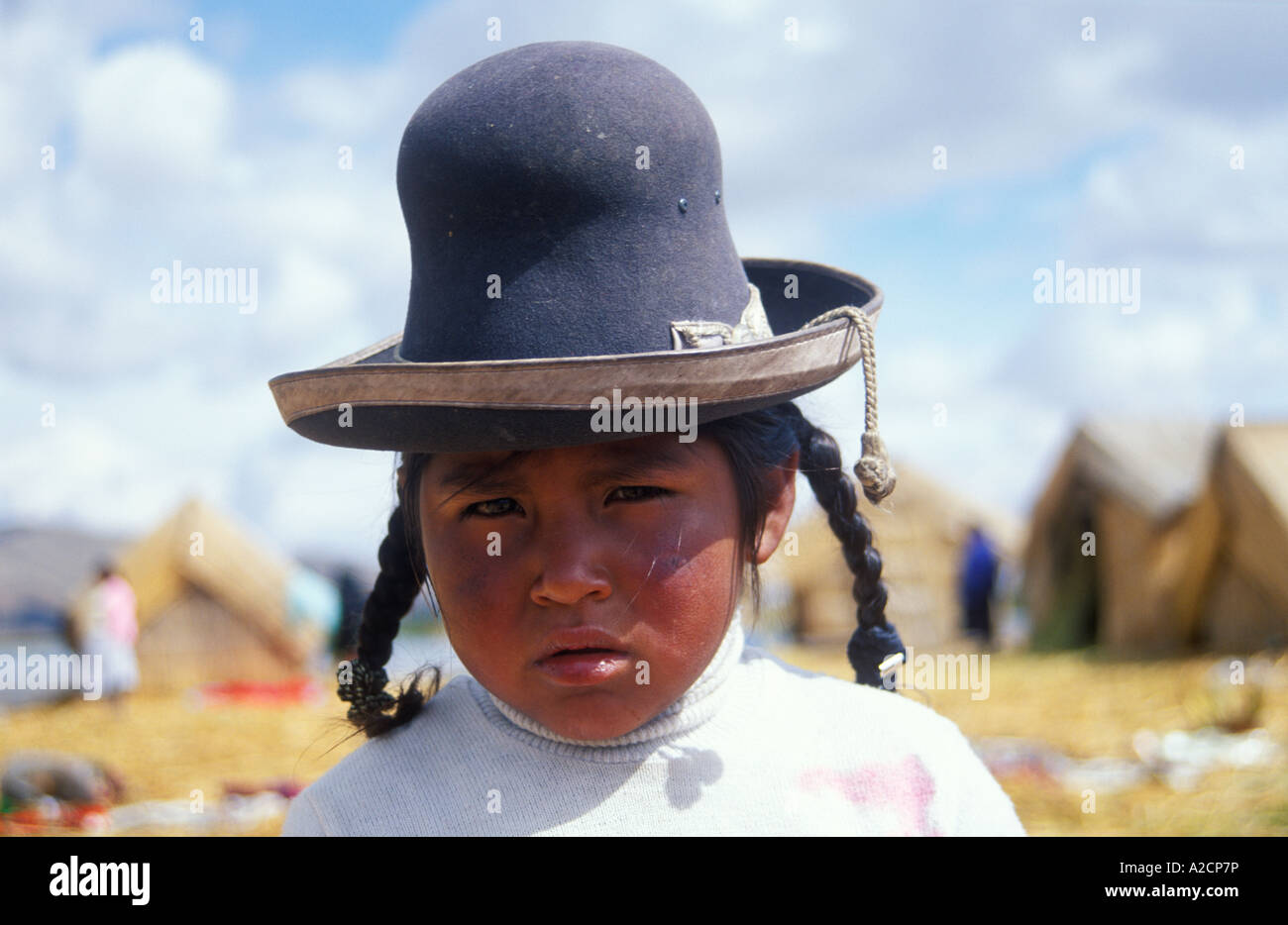 portrait of a little girl with a traditional hat and braids on a Uro ...