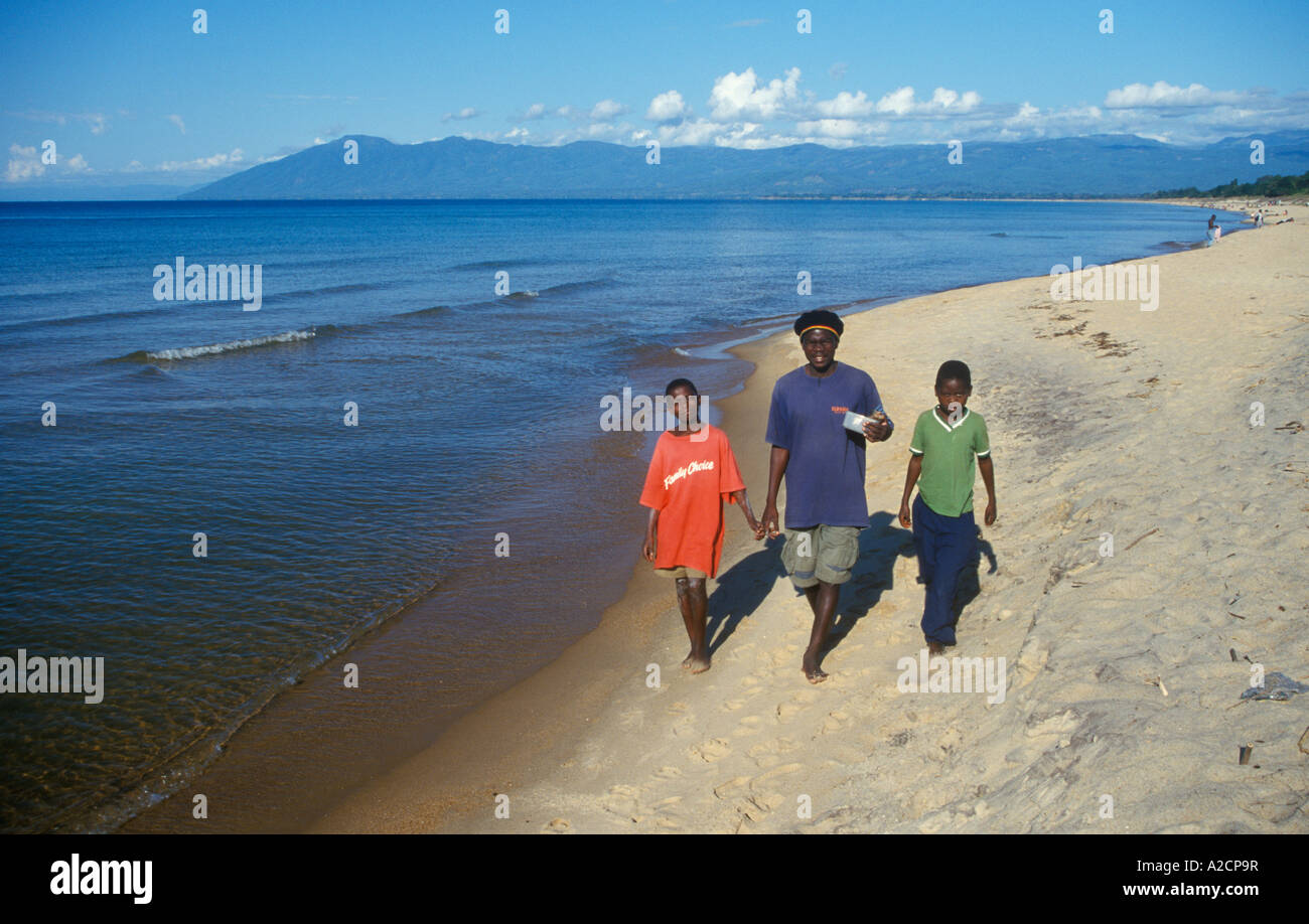 a native young man and two young boys walking along Kande Beach at Lake ...