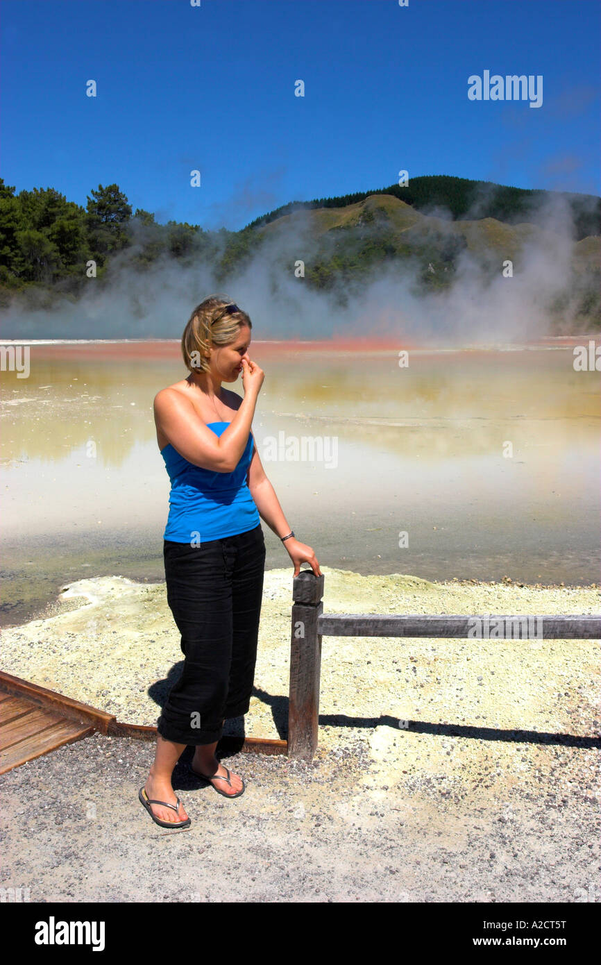 Young woman piching her nose due to the smell of sulphur at a volcanic ...