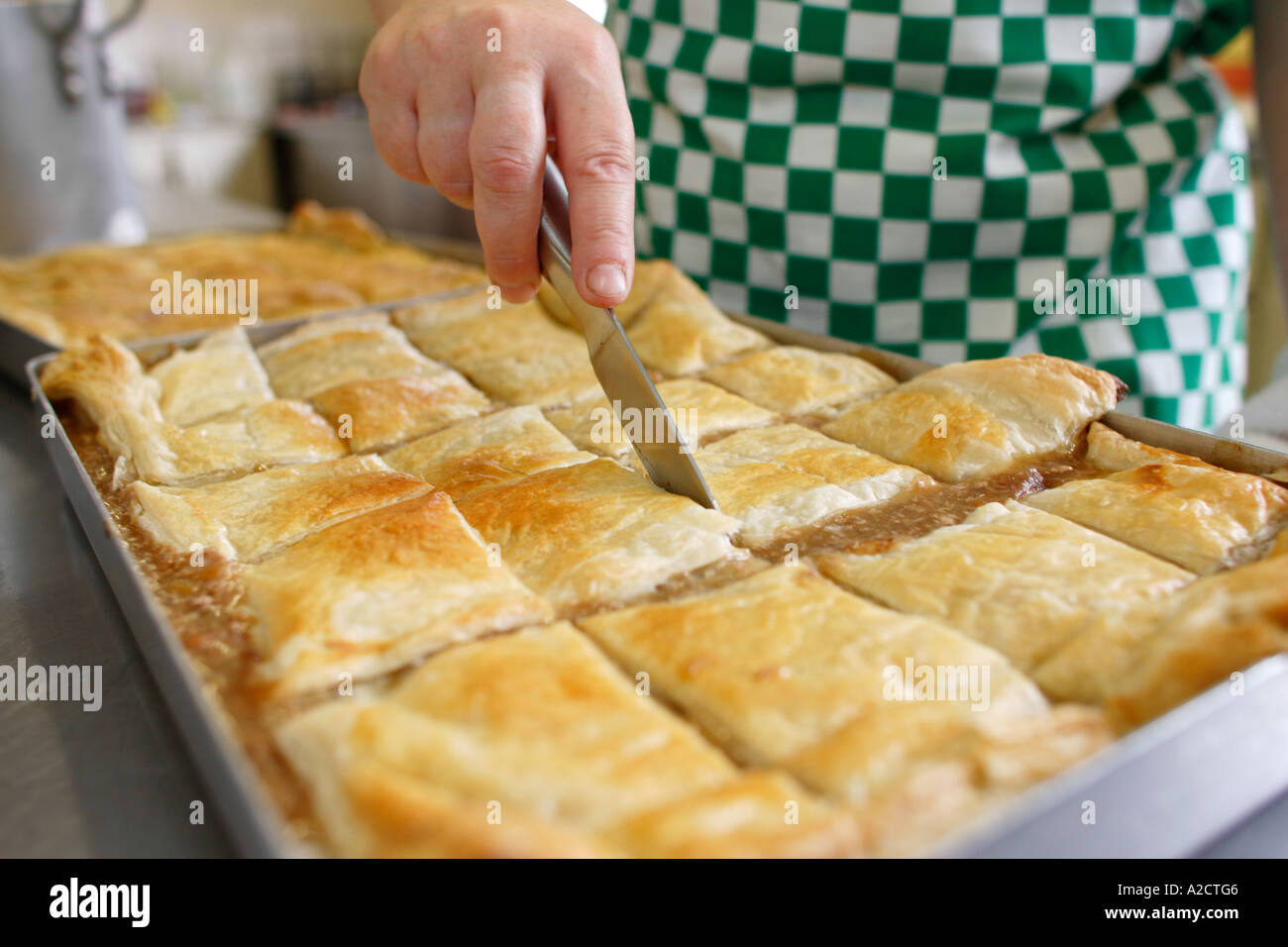 A pie being cut up in a UK school kitchen Stock Photo - Alamy