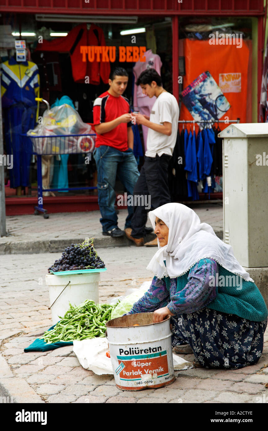 A woman selling produce at a sidewalk markets in downtown Isparta ...
