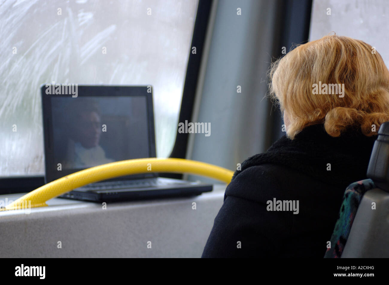 A bus passenger watches a film on her laptop while travelling to her ...